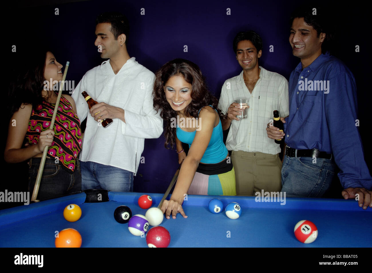 Young adults playing pool and drinking beer Stock Photo - Alamy