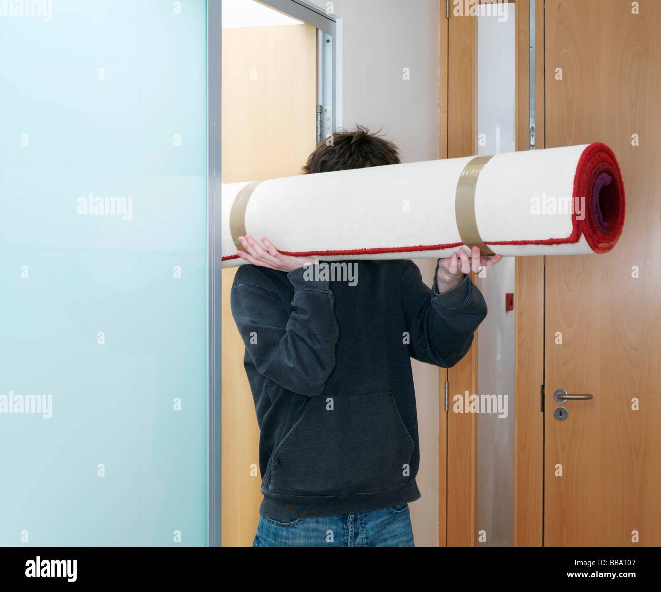 Man carrying rolled rug Stock Photo - Alamy