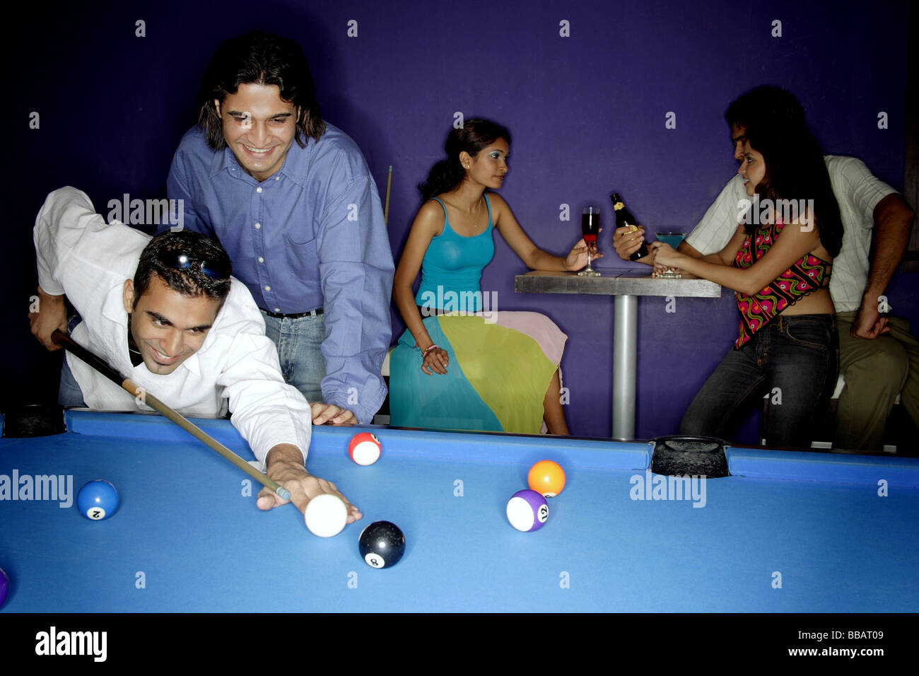 Young adults playing pool and drinking beer Stock Photo - Alamy