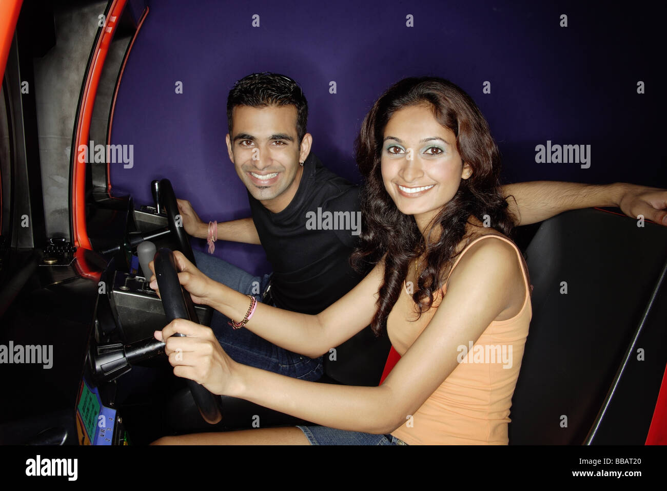 Couple in a video game arcade, playing games, smiling at camera Stock ...