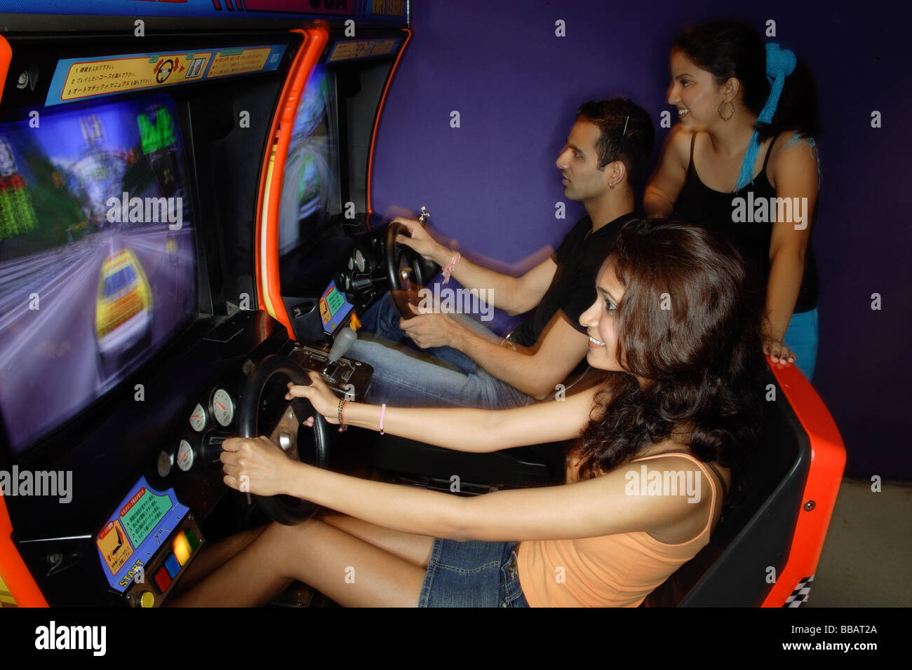 Young adults playing games in amusement arcade Stock Photo - Alamy
