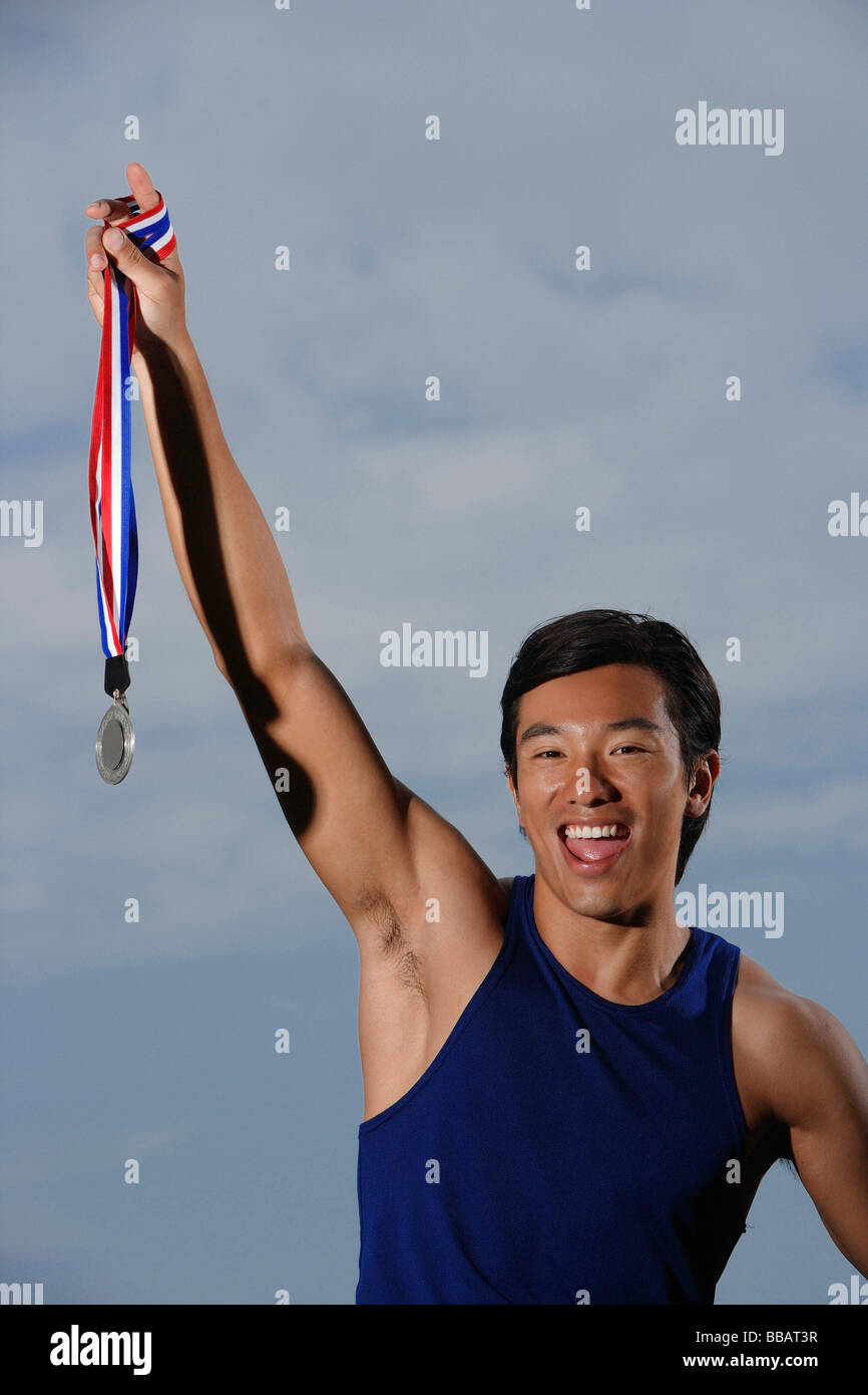 Man winning race, holding medal, smiling Stock Photo - Alamy