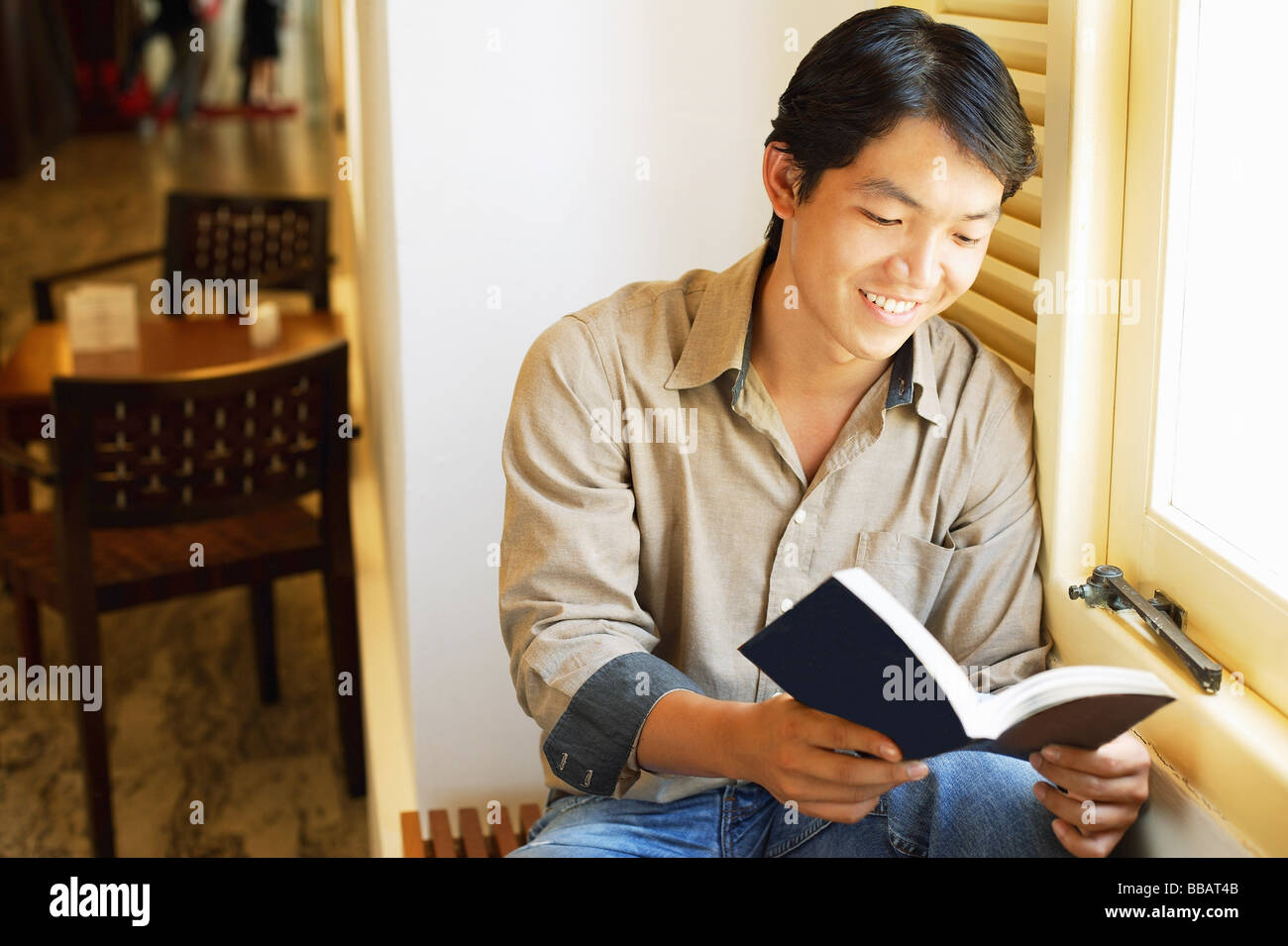 Man reading book, smiling Stock Photo - Alamy