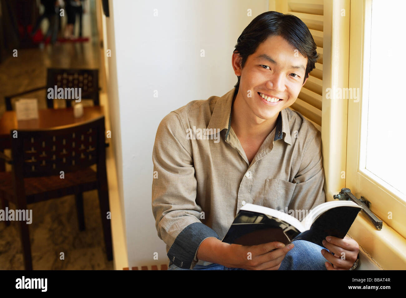 Man holding book, smiling Stock Photo - Alamy