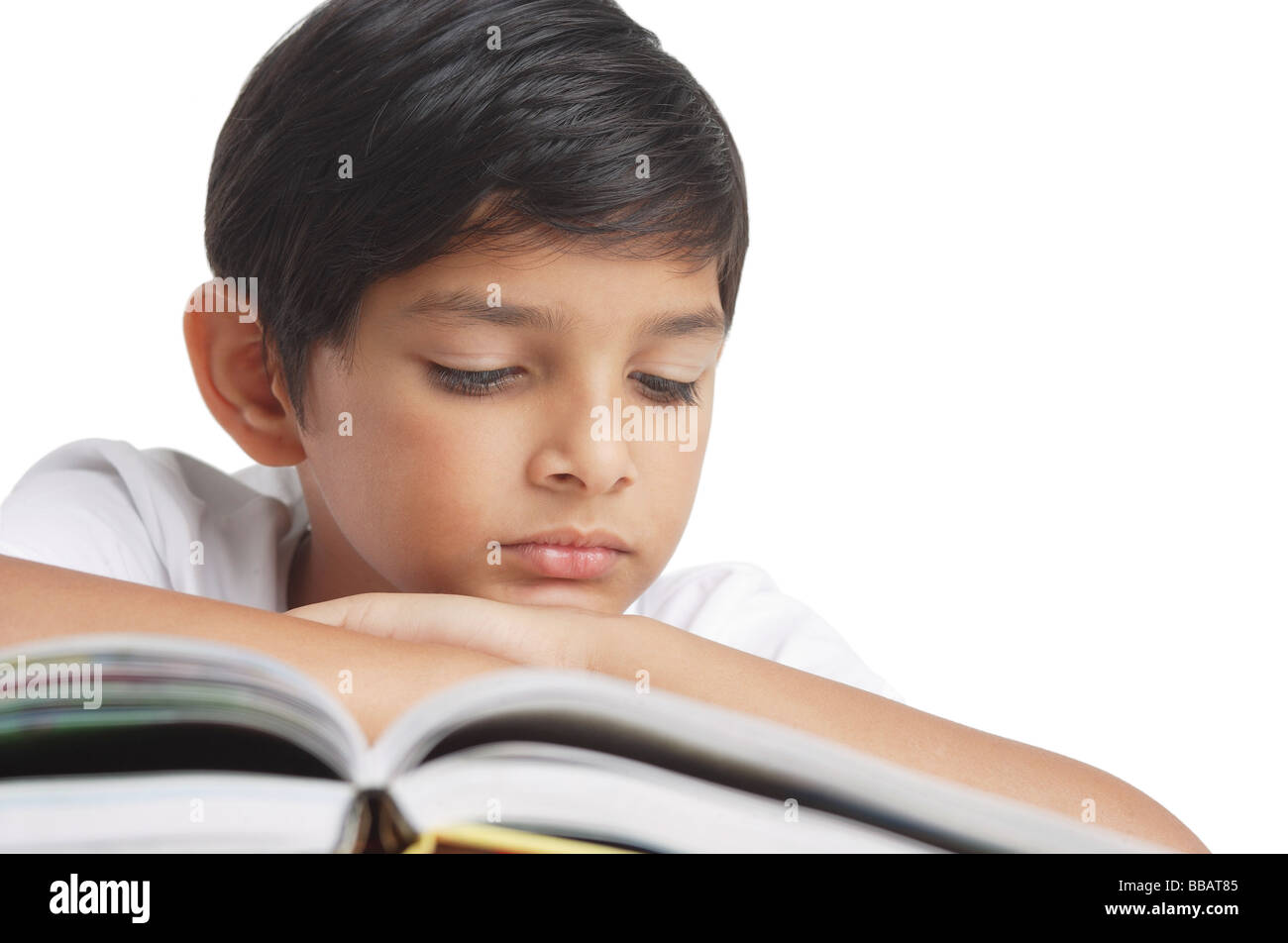 Boy reading book, leaning on hand Stock Photo - Alamy