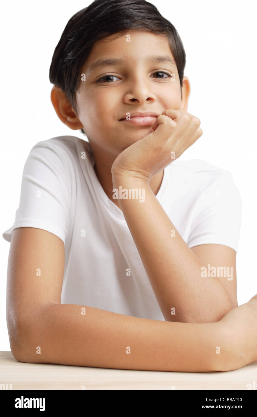 Boy with hand on chin, looking at camera Stock Photo - Alamy