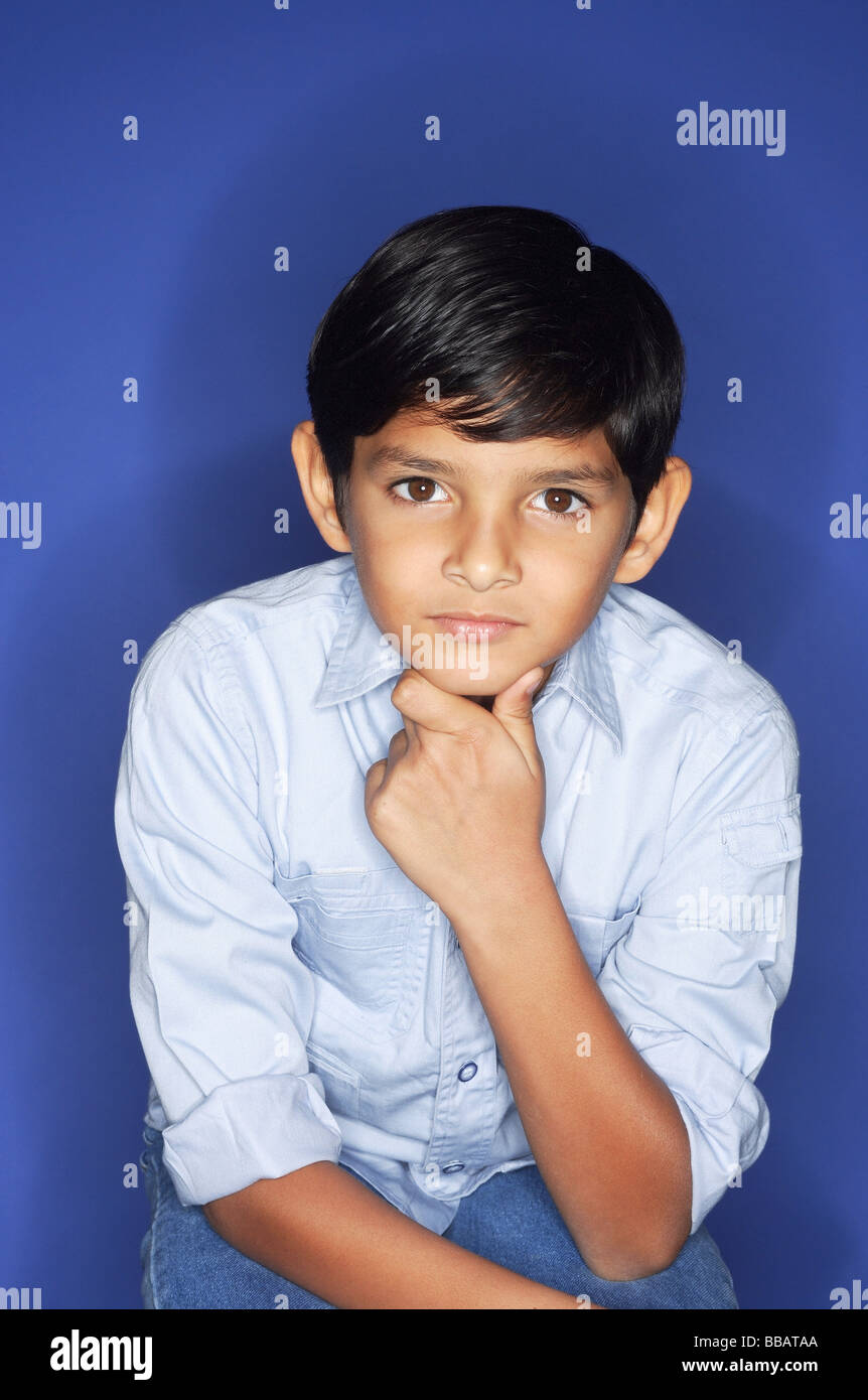 Boy looking at camera, hand on chin, portrait Stock Photo - Alamy