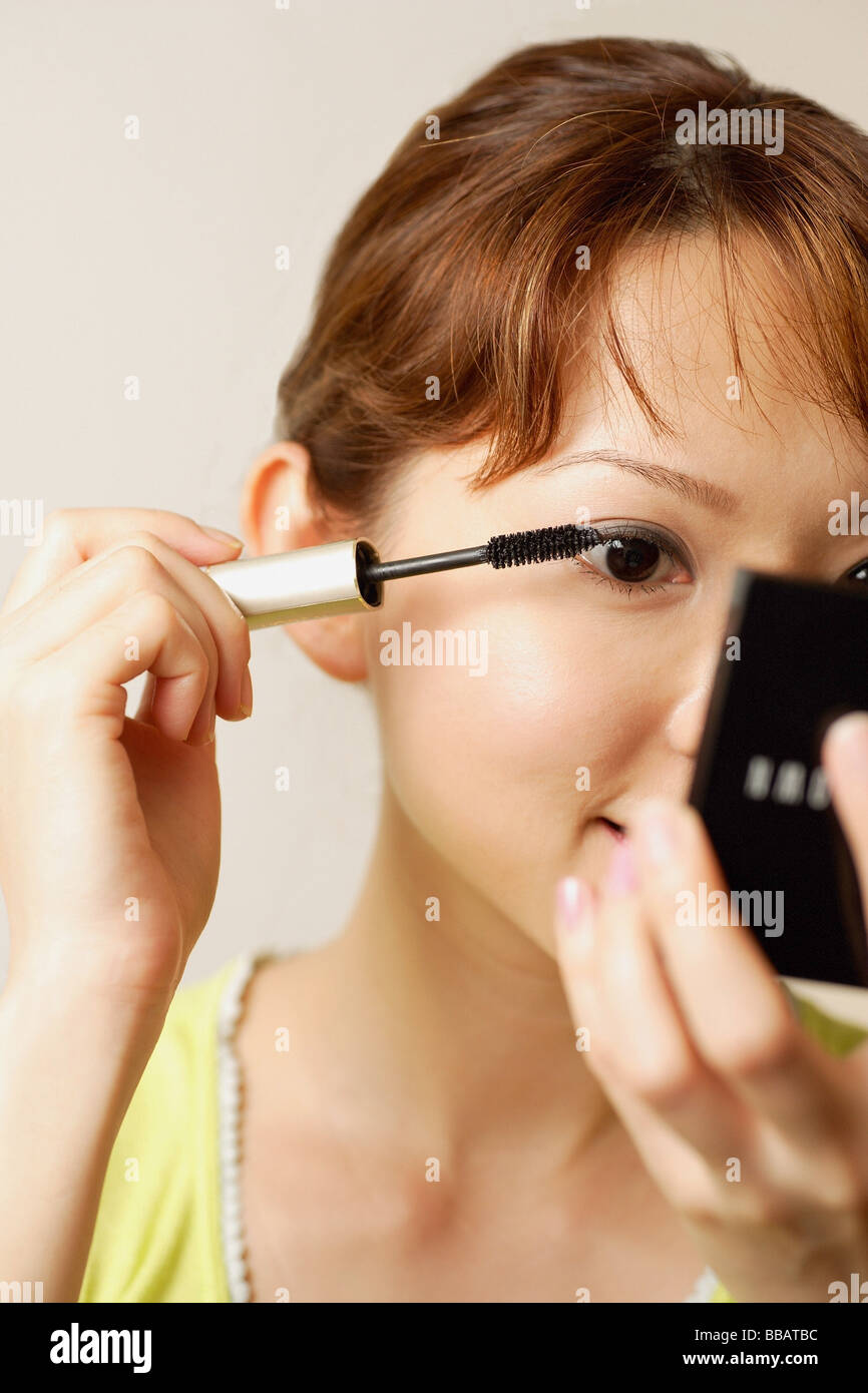 Woman applying mascara Stock Photo - Alamy