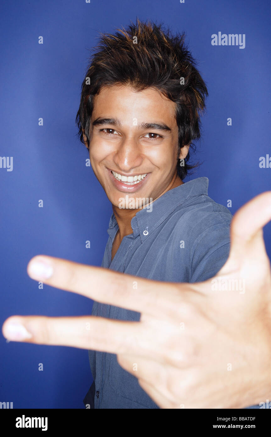 Man smiling, making hand sign Stock Photo - Alamy