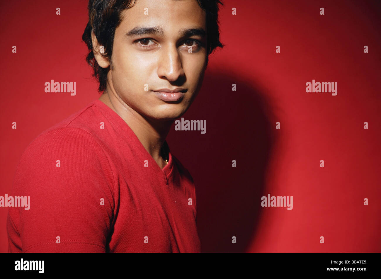 Man in red shirt against red background Stock Photo - Alamy