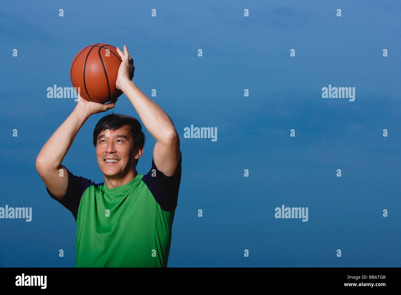 Man playing basketball, throwing ball, smiling Stock Photo - Alamy