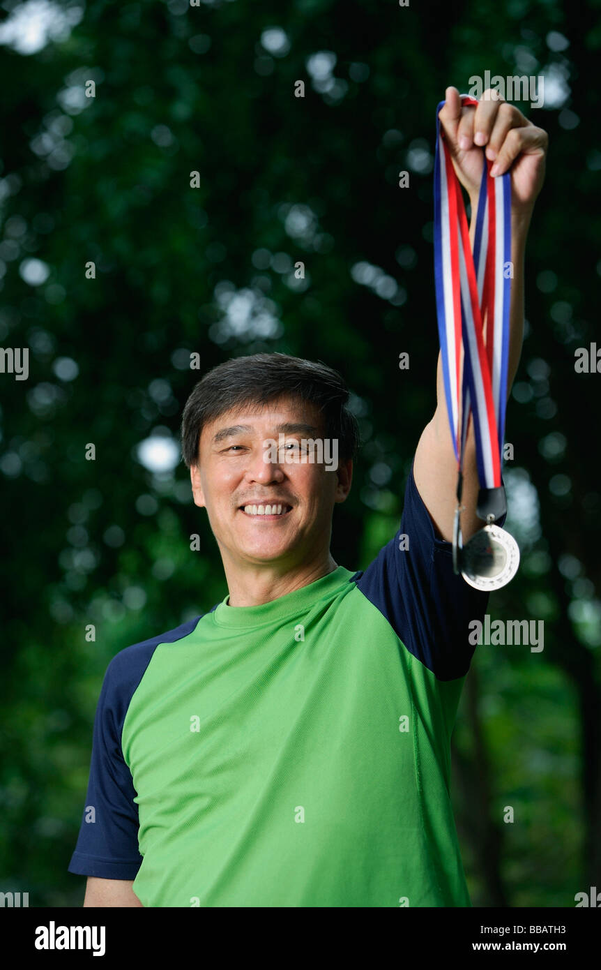 Man holding medals, winner, smiling Stock Photo - Alamy