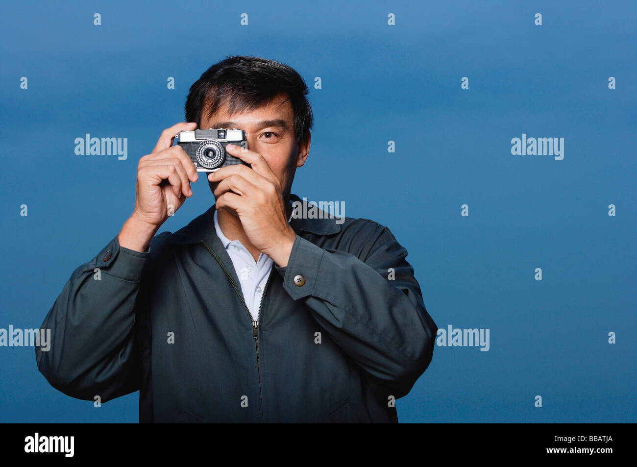 Man taking picture with camera up to eye Stock Photo - Alamy