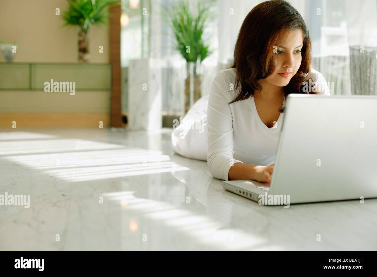 Woman lying on floor, using laptop Stock Photo - Alamy