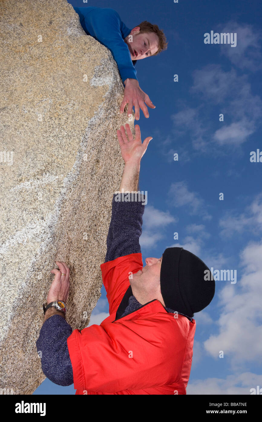 Climber offering hand to fellow climber Stock Photo - Alamy