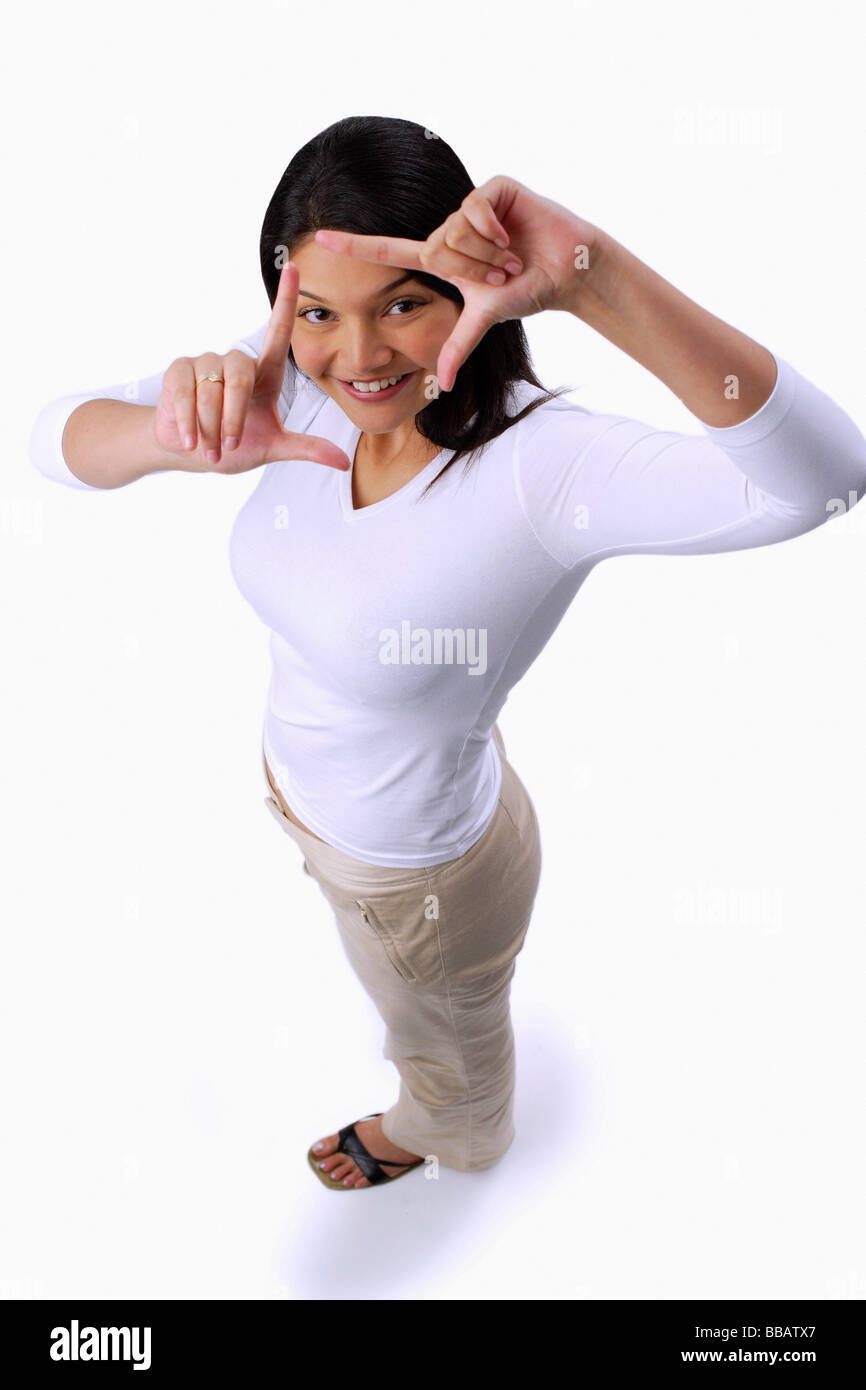 Woman looking up at camera, looking through finger frame Stock Photo ...