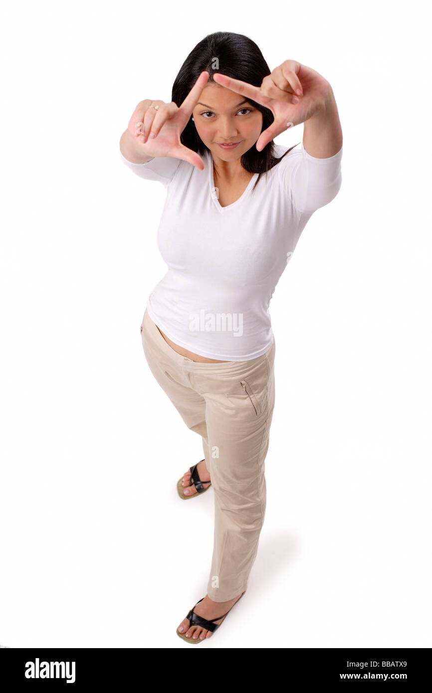 Woman looking at camera through finger frame Stock Photo - Alamy