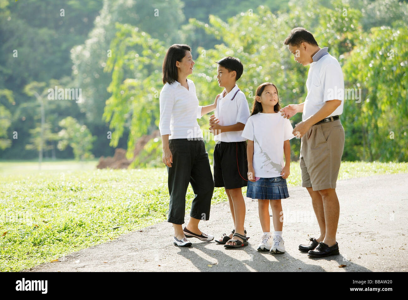 Family standing and talking in park Stock Photo - Alamy