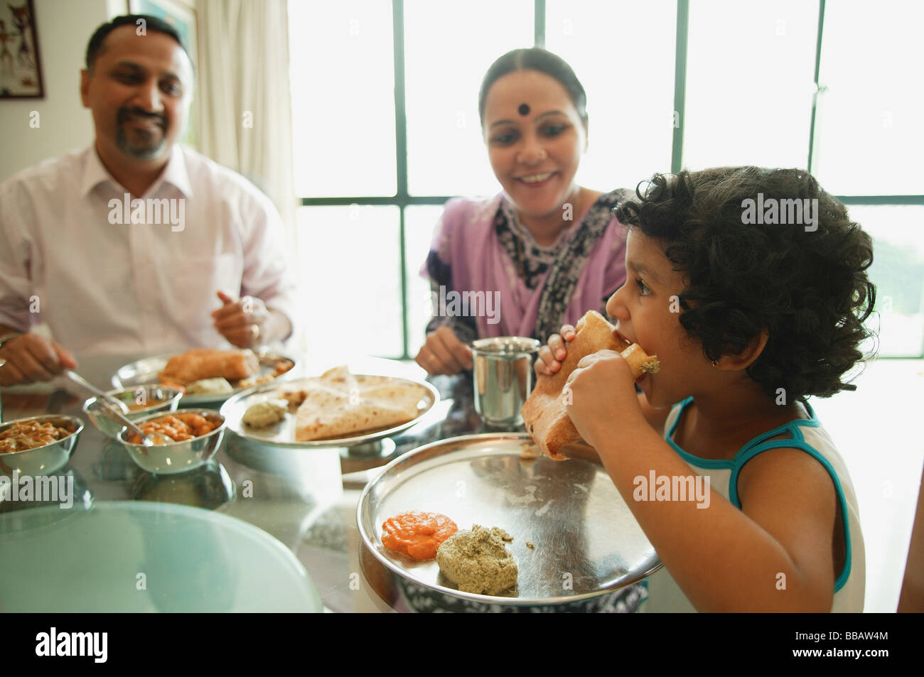 Family of three sitting down to a meal Stock Photo - Alamy