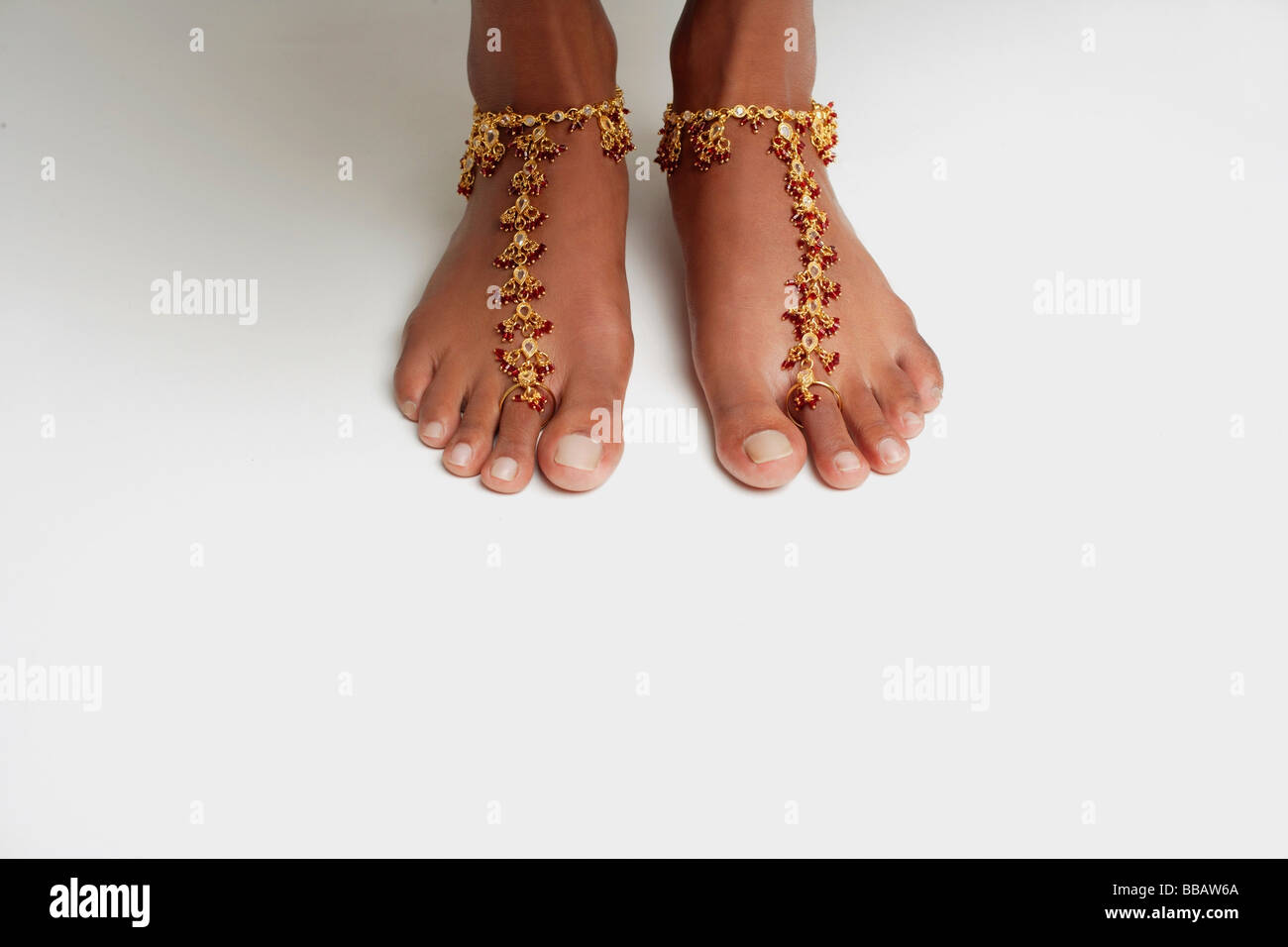 Woman's feet with anklet against white floor Stock Photo - Alamy