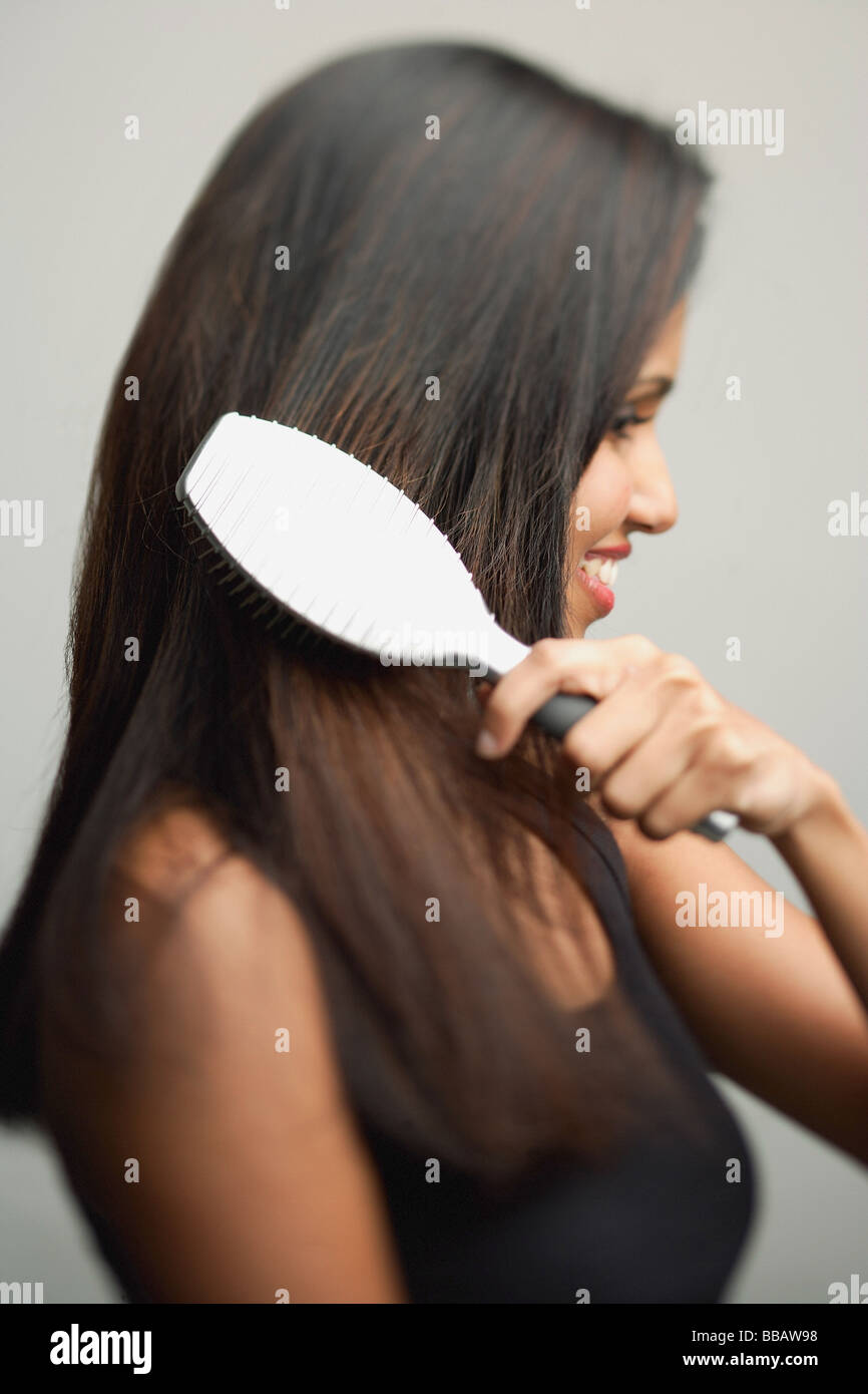 Woman brushing her hair, side view Stock Photo - Alamy