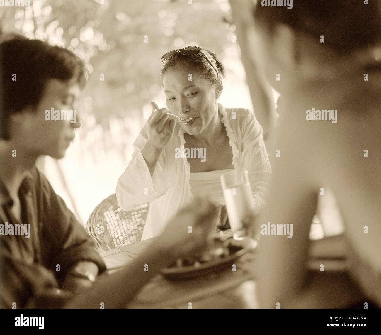 Woman eating with friends Stock Photo - Alamy
