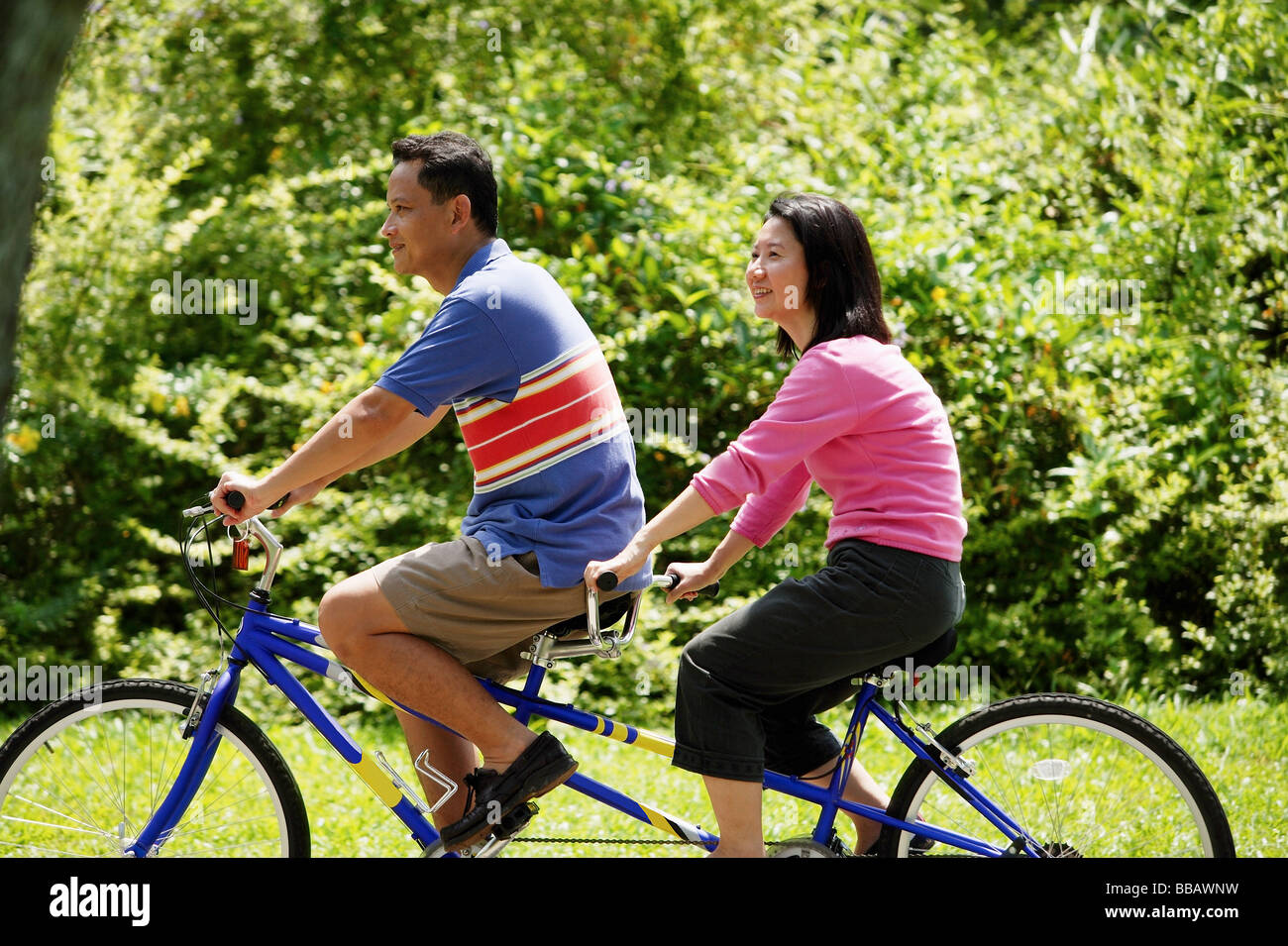 Couple in park, riding tandem bicycle Stock Photo - Alamy