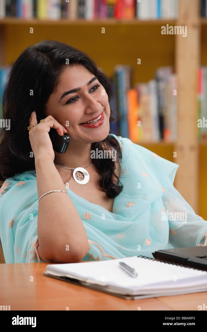 Woman in library, using mobile phone Stock Photo - Alamy
