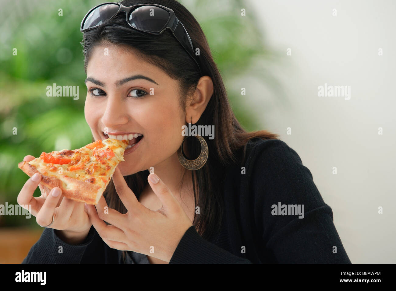 Woman eating a slice of pizza Stock Photo - Alamy