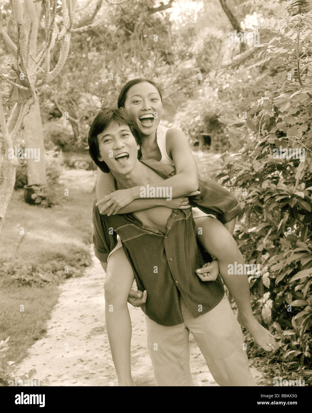 Man carrying woman on back, laughing Stock Photo - Alamy