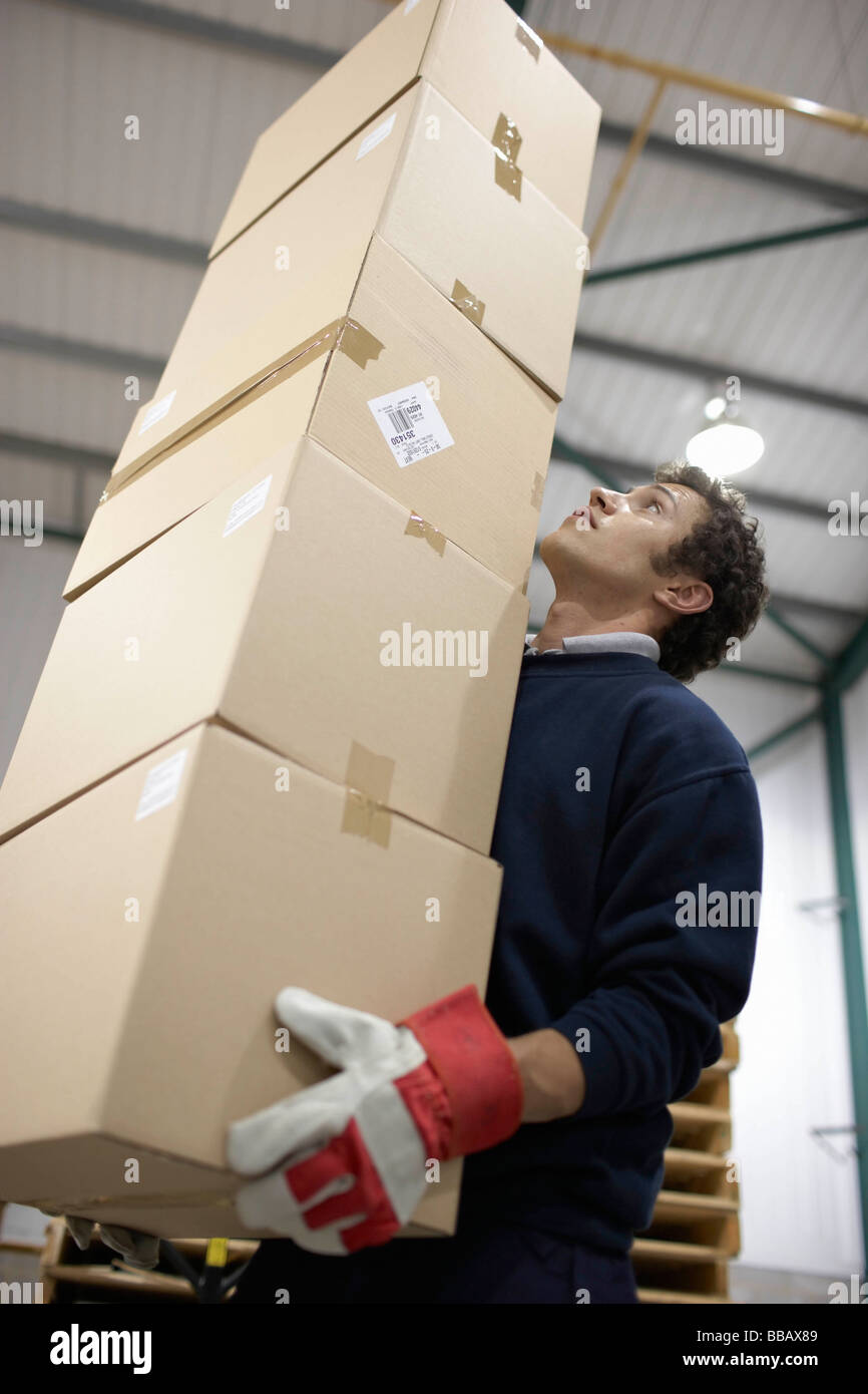 Worker carrying pile of boxes Stock Photo - Alamy