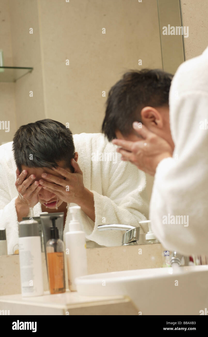 Young man washing face in bathroom Stock Photo - Alamy