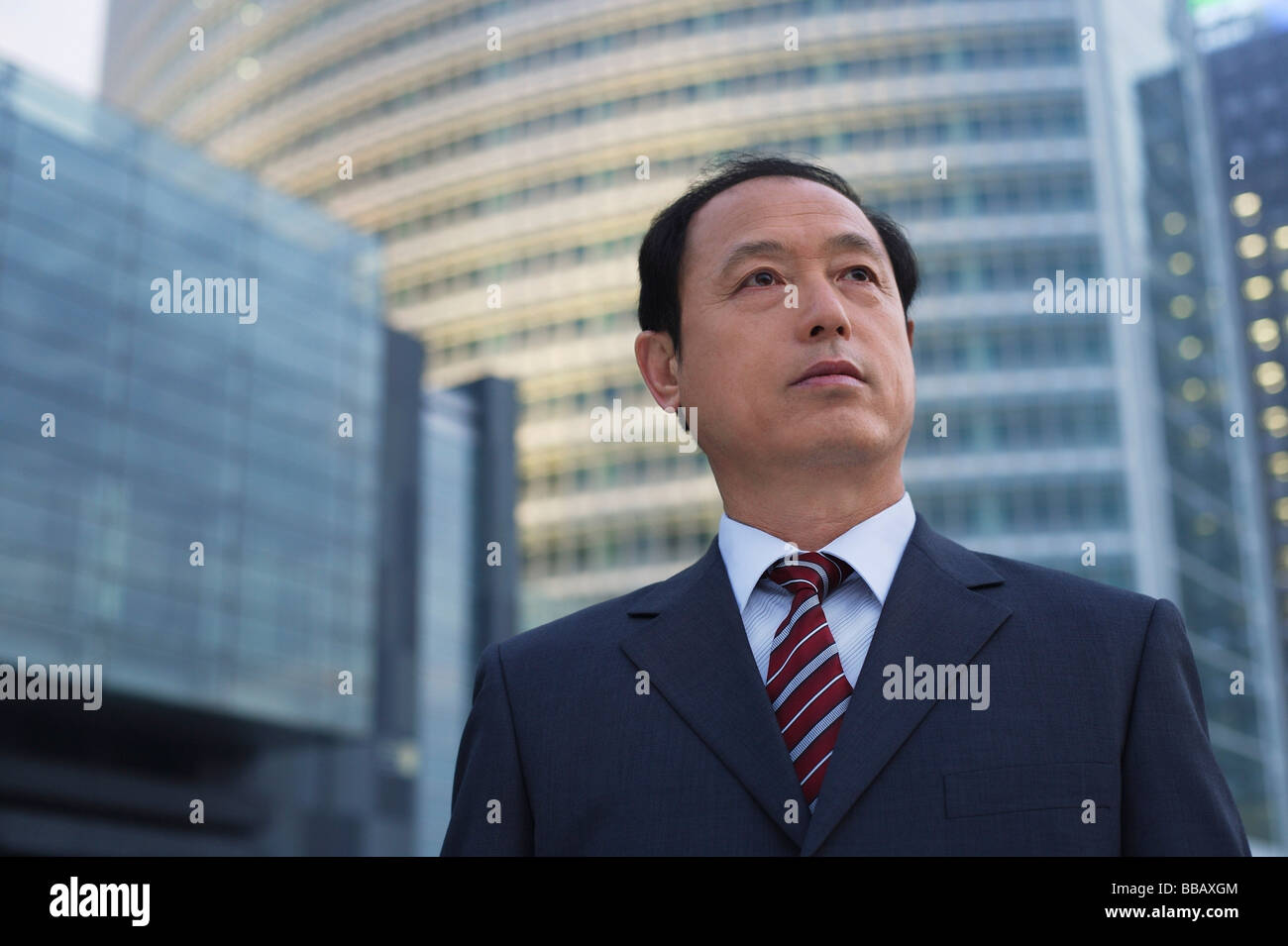 A businessman stands in front of a skyscraper Stock Photo - Alamy