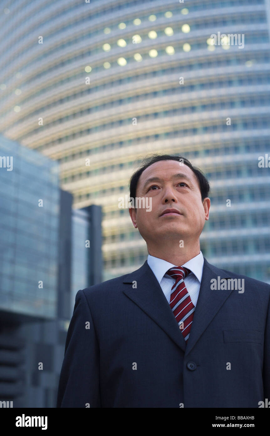 A businessman stands in front of a skyscraper Stock Photo - Alamy