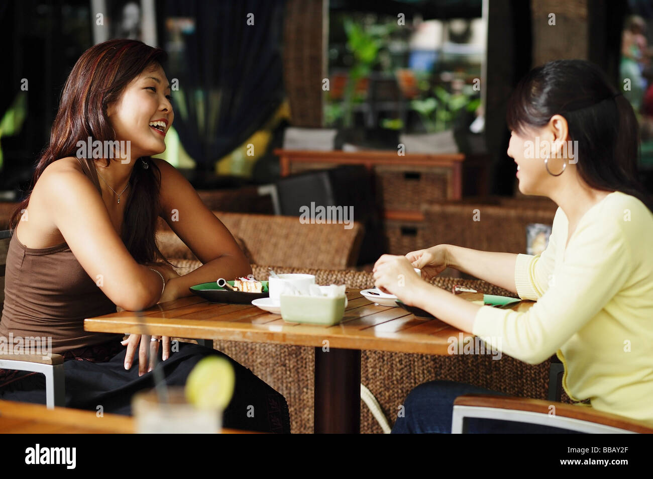 Young women sitting at cafe Stock Photo - Alamy