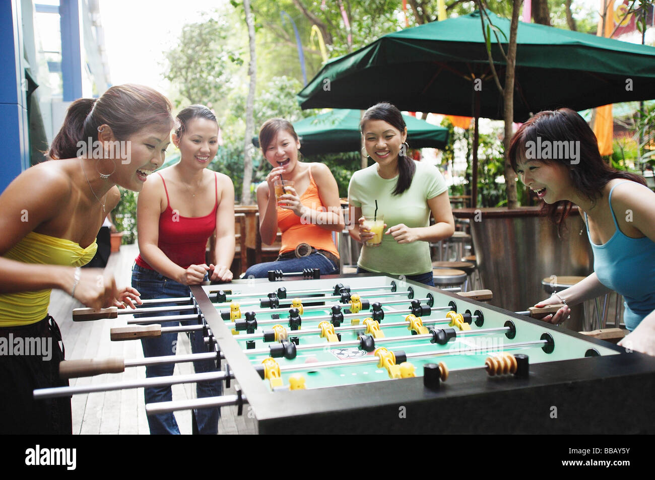 Young women playing foosball Stock Photo - Alamy