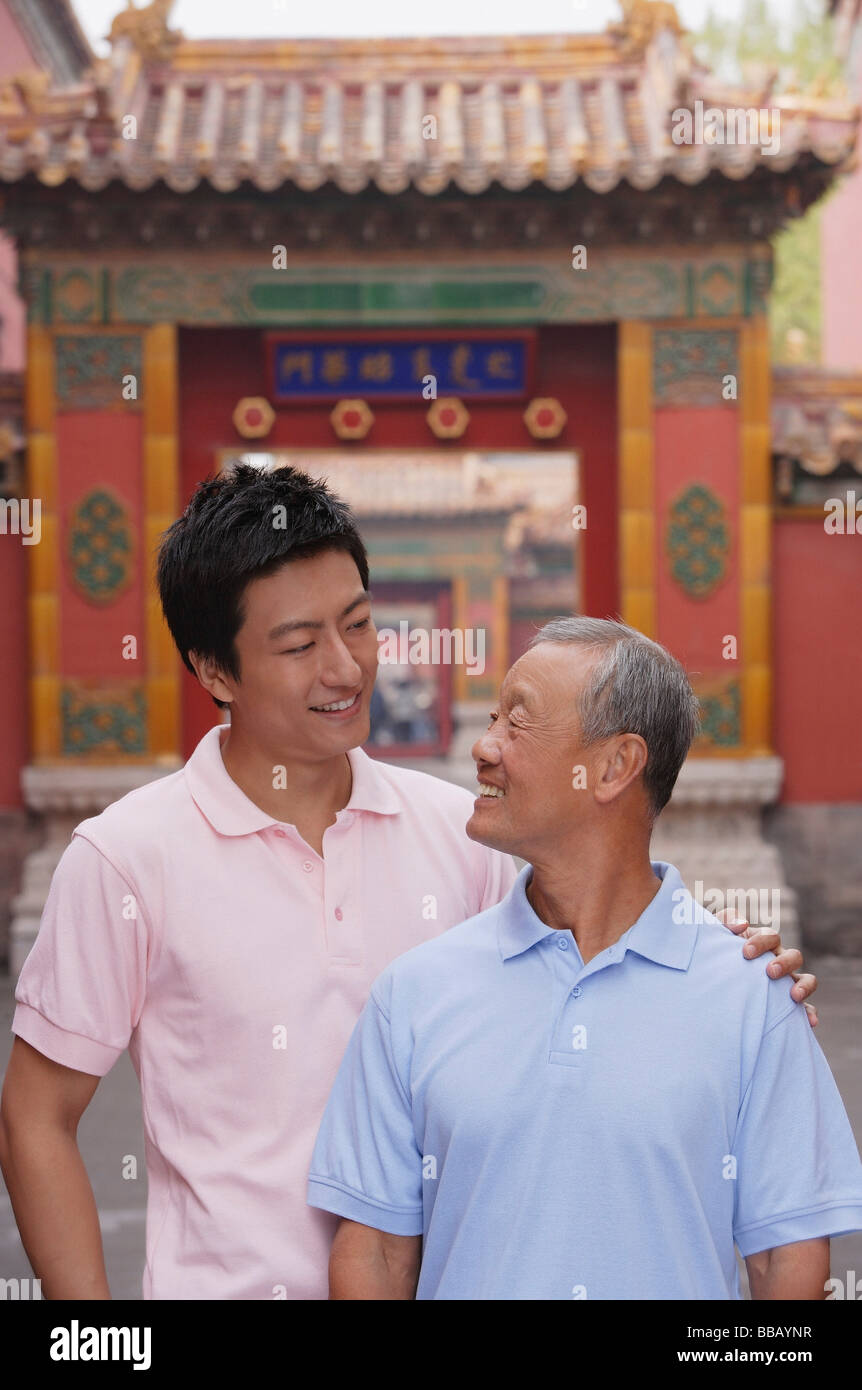 A grandfather and grandson stand in front of a tourist destination for ...