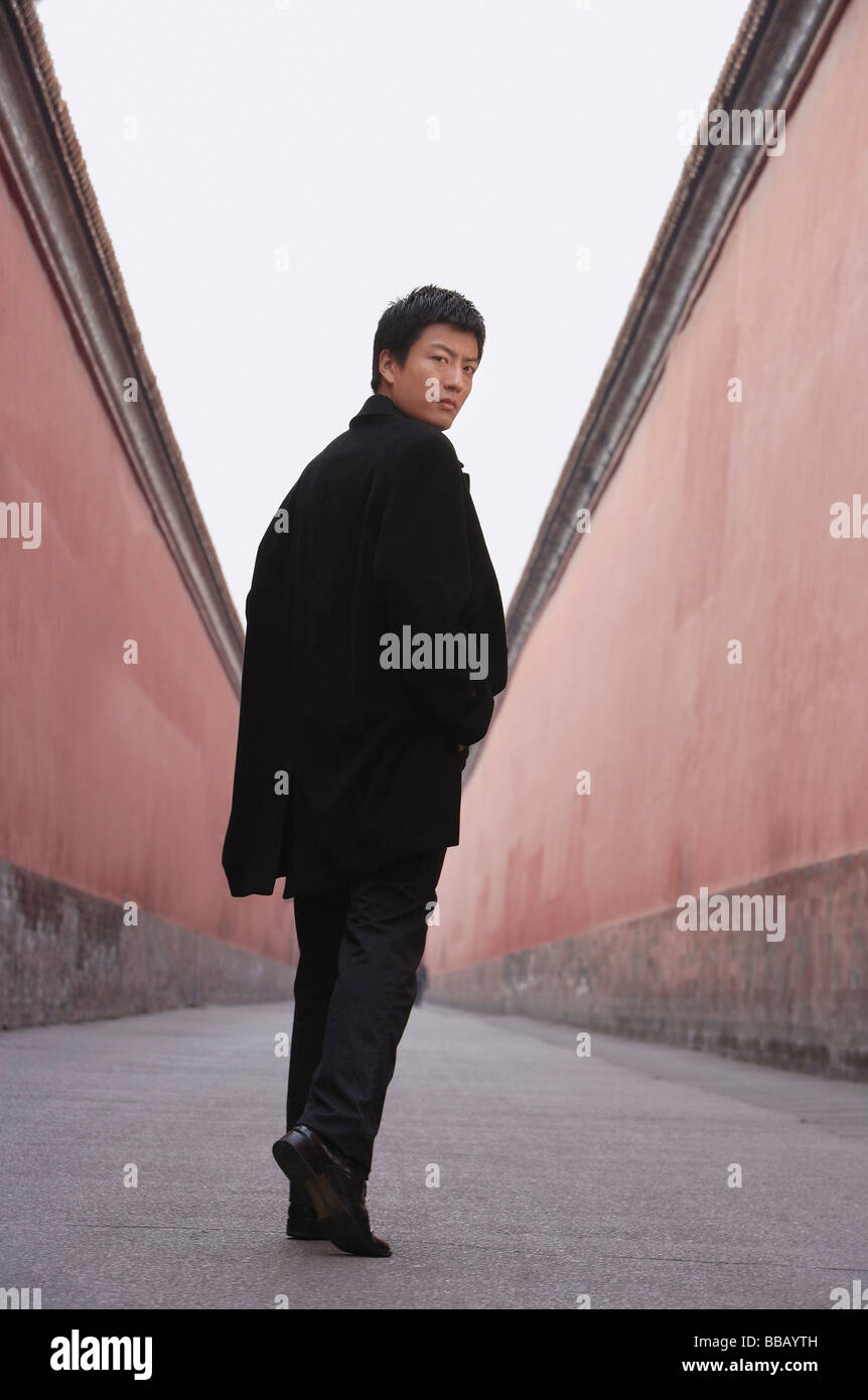 A man looks back at the camera as he walks away Stock Photo - Alamy