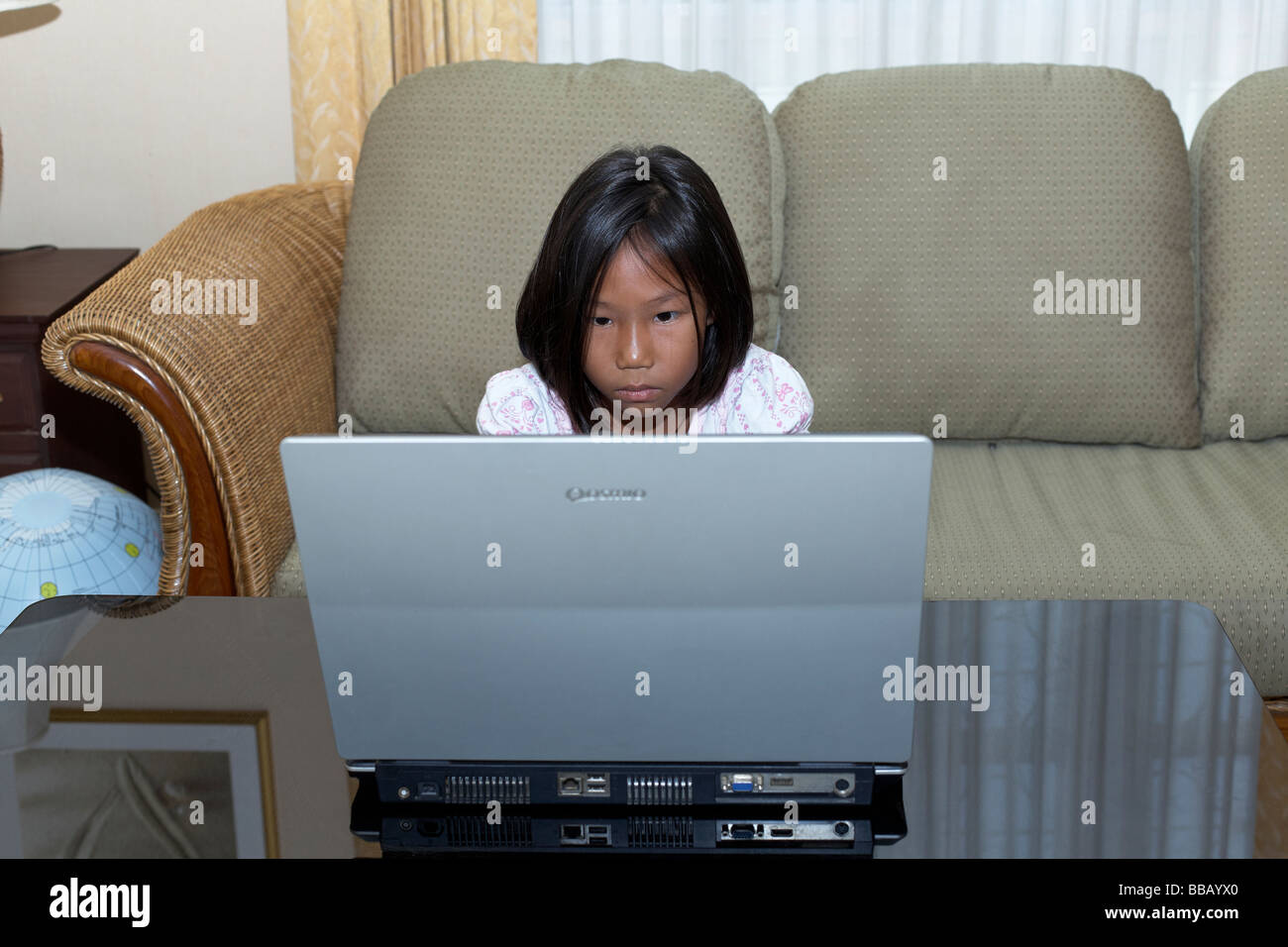 Child laptop computer. A young Thai girl using a laptop computer at ...