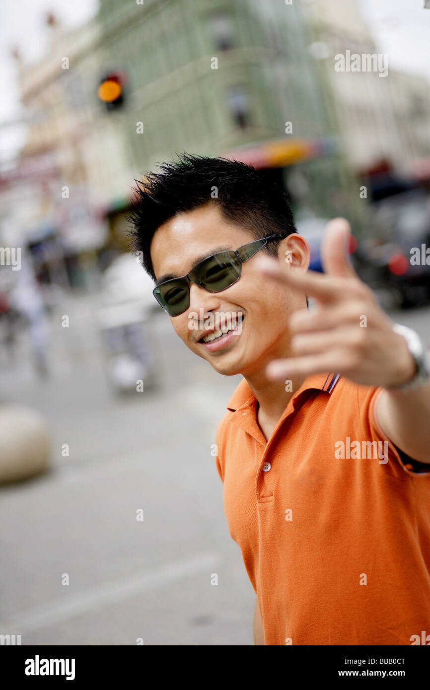 Man in sunglasses, looking at camera, making hand sign Stock Photo - Alamy