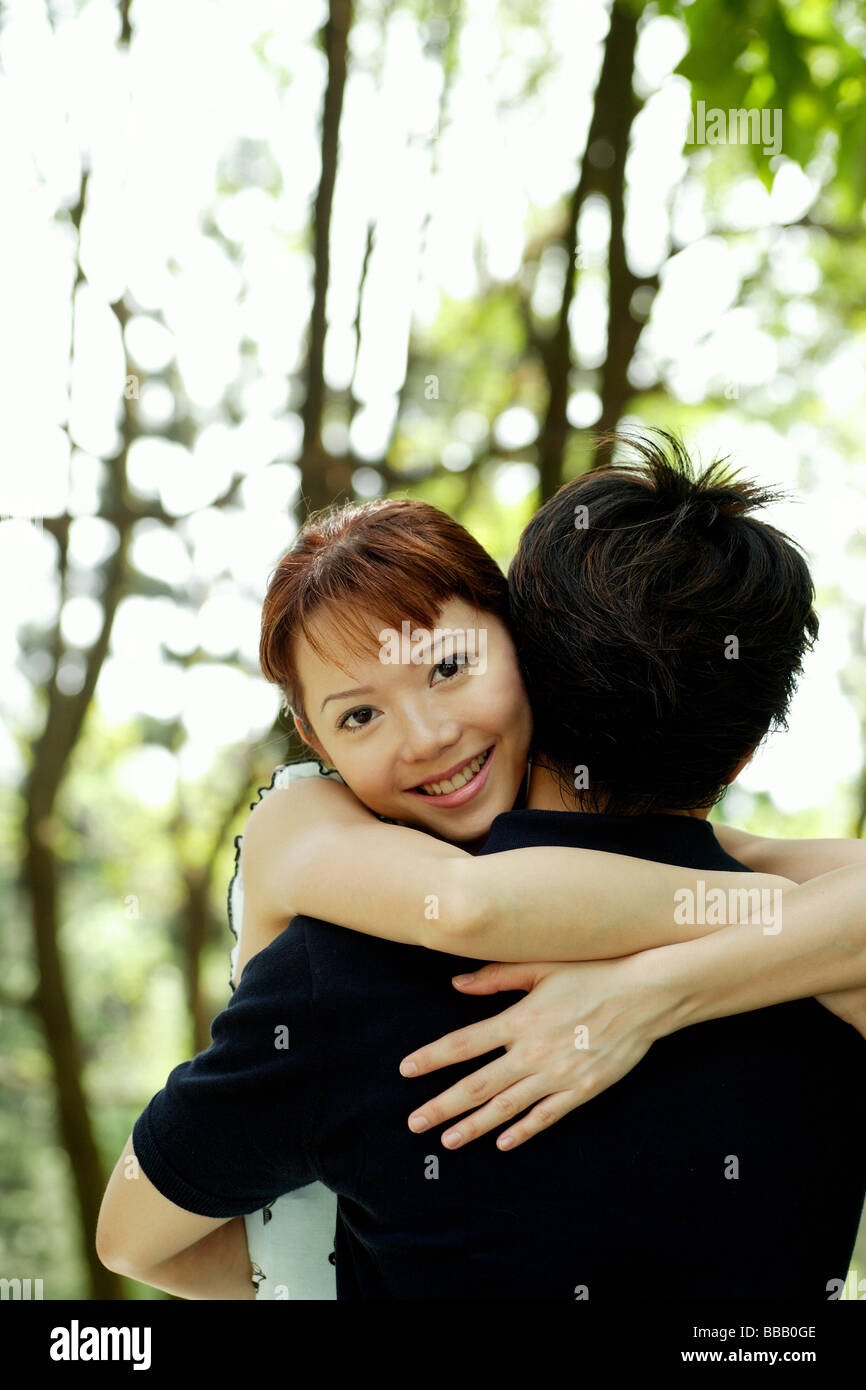 Woman hugging man, facing camera Stock Photo - Alamy