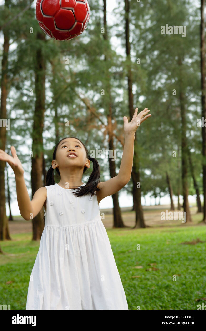 Girl in white dress, tossing ball in park Stock Photo - Alamy