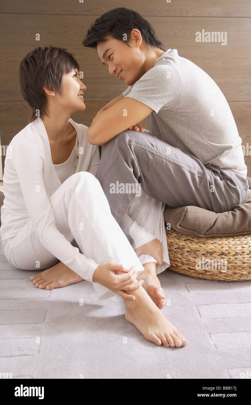 Couple sitting side by side, looking at each other Stock Photo - Alamy