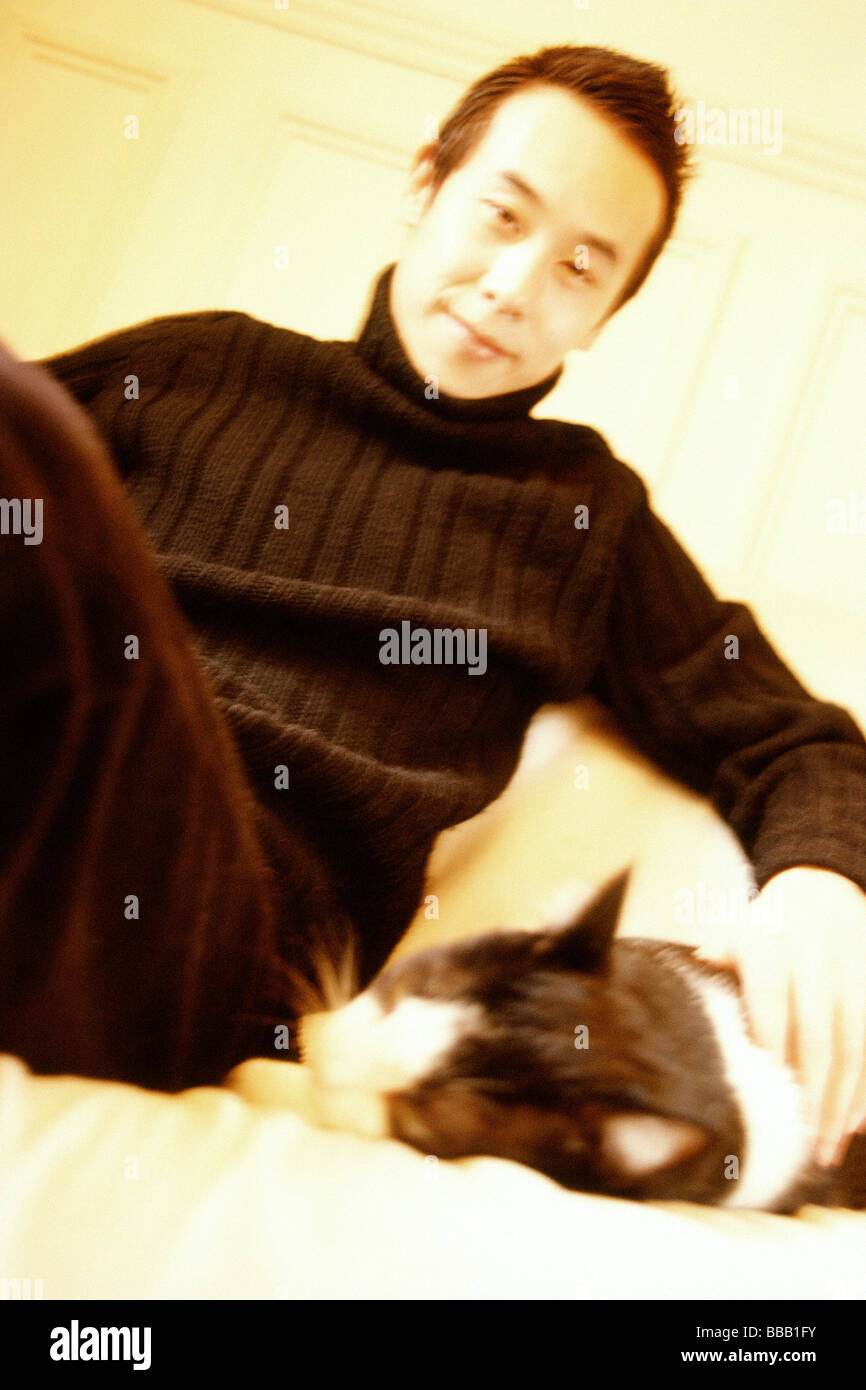 Man sitting and petting cat Stock Photo - Alamy
