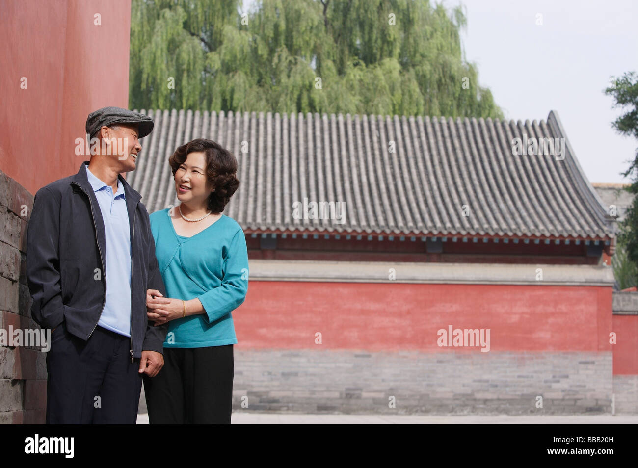 A man and woman link arms as they walk together Stock Photo - Alamy