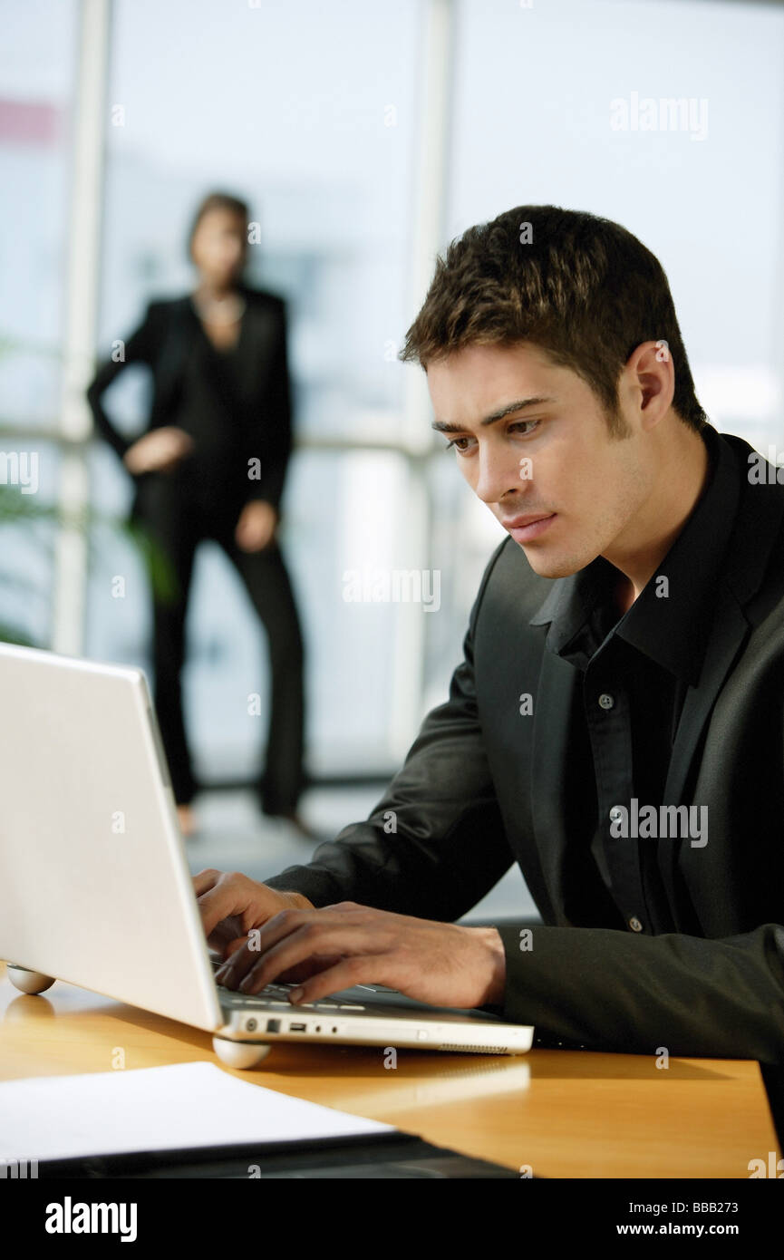 Male executive dressed in black, using laptop Stock Photo - Alamy