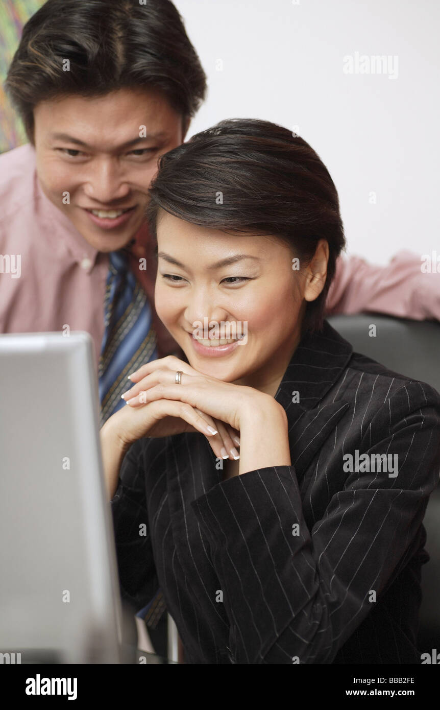 Businesspeople, side by side, looking at laptop Stock Photo - Alamy