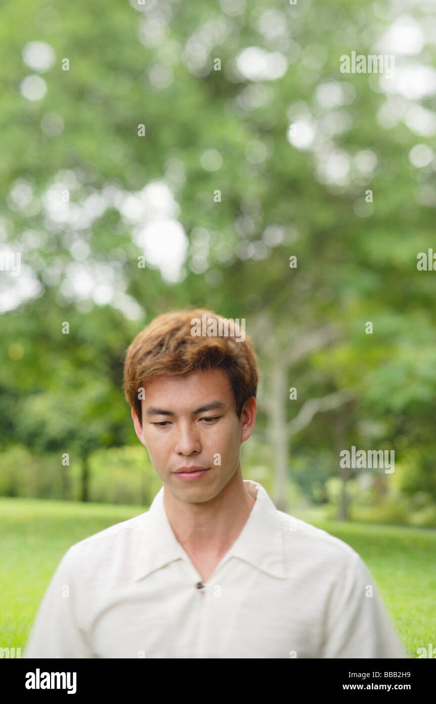 Man outdoors, looking down, head shot Stock Photo - Alamy