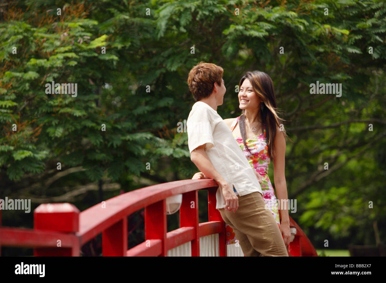 Happy young couple leaning on bridge railing hi-res stock photography ...