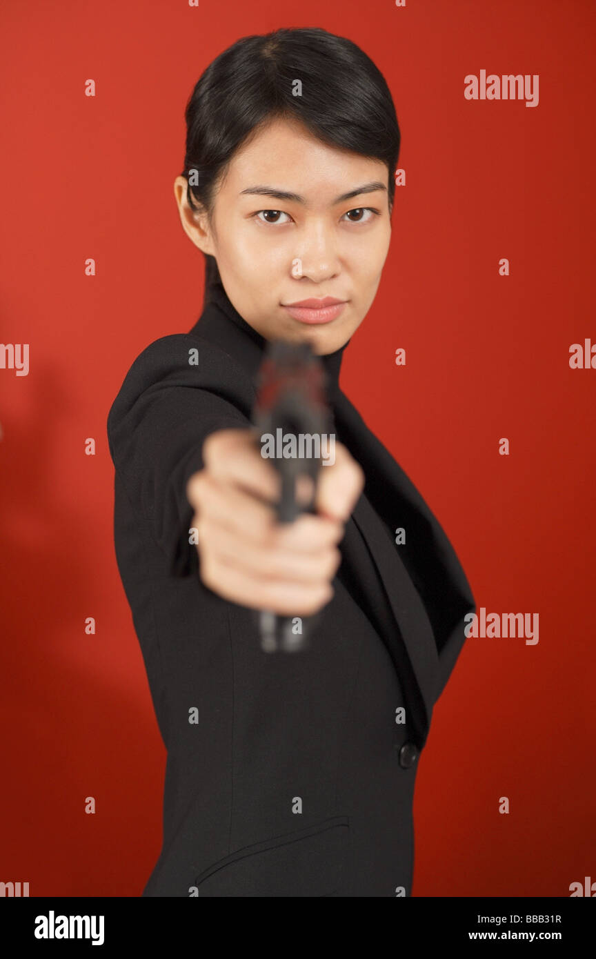 Female executive pointing gun towards camera Stock Photo - Alamy